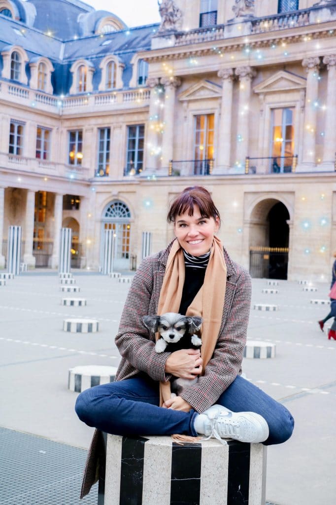 A woman holding a dog in front of a building to celebrate Love Your Pet ...