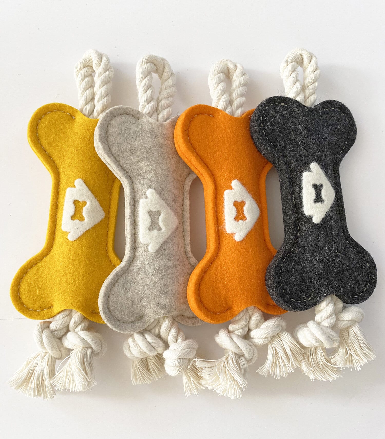 Four felt dog bone toys with tassels, from Oprah’s Favorite Brands, and ...